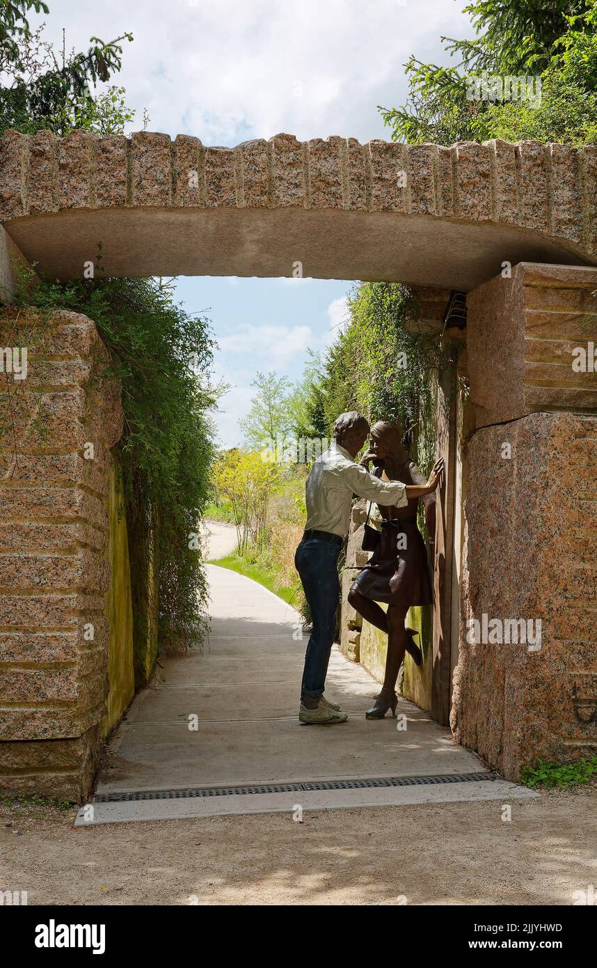statues standing under stone arch, man, woman, intimate conversation ...