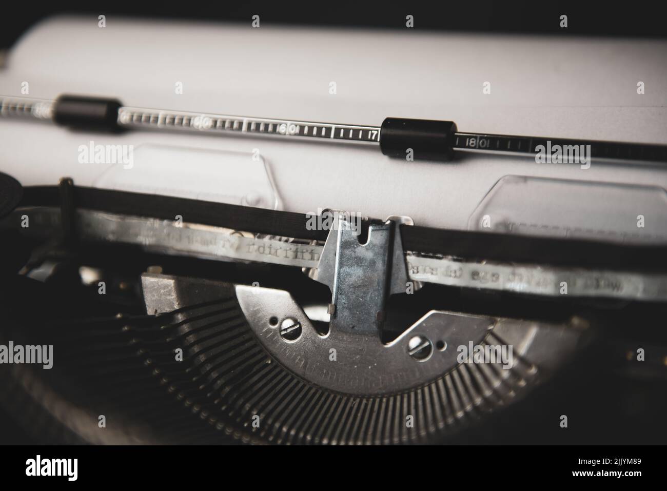 Closeup view of old vintage typewriter with white paper in paper feed ...