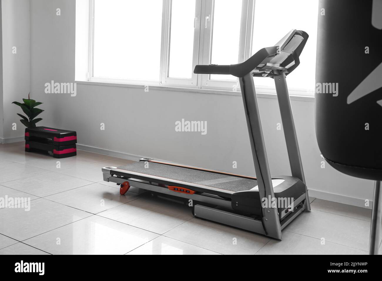 Modern treadmill near window in gym Stock Photo - Alamy