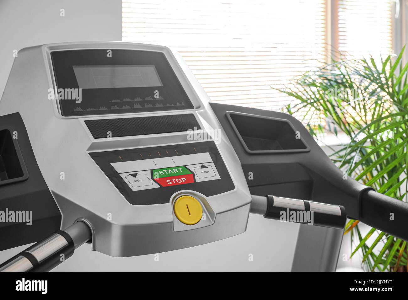 Modern treadmill near window in gym, closeup Stock Photo - Alamy