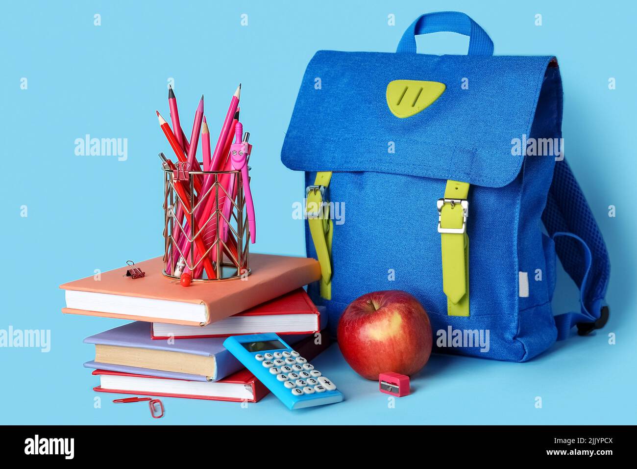 Cup with school stationery, apple and backpack on blue background Stock ...