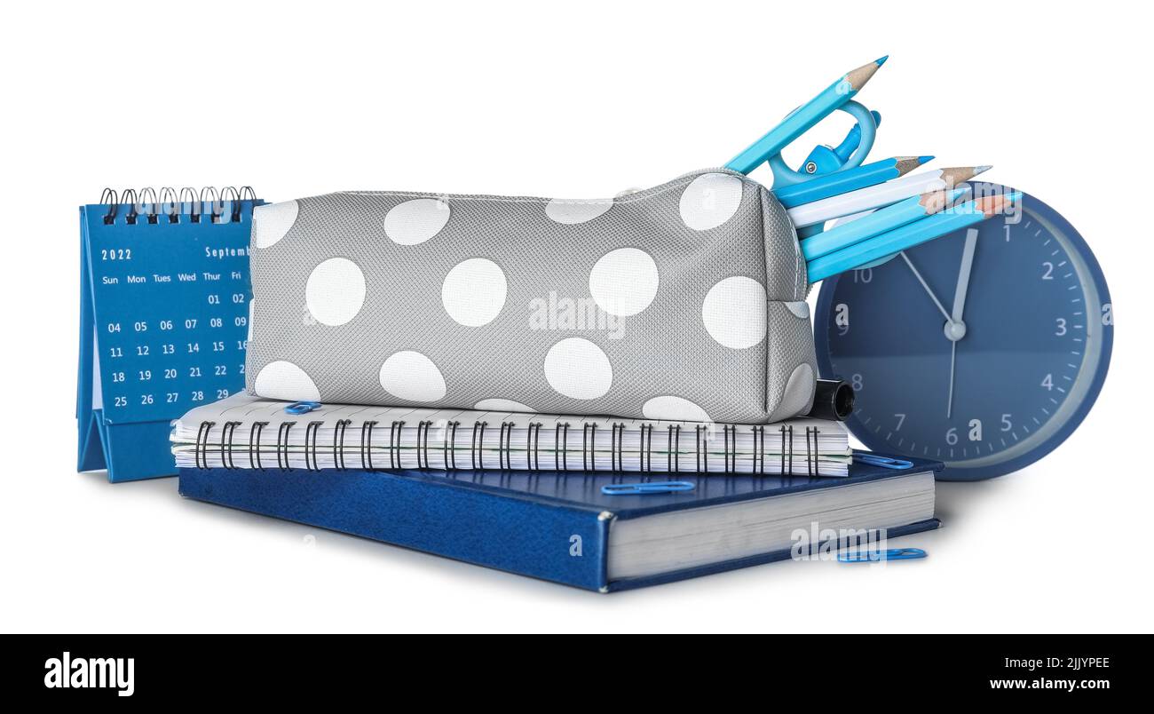 Pencil case with book, alarm clock and calendar on white background ...