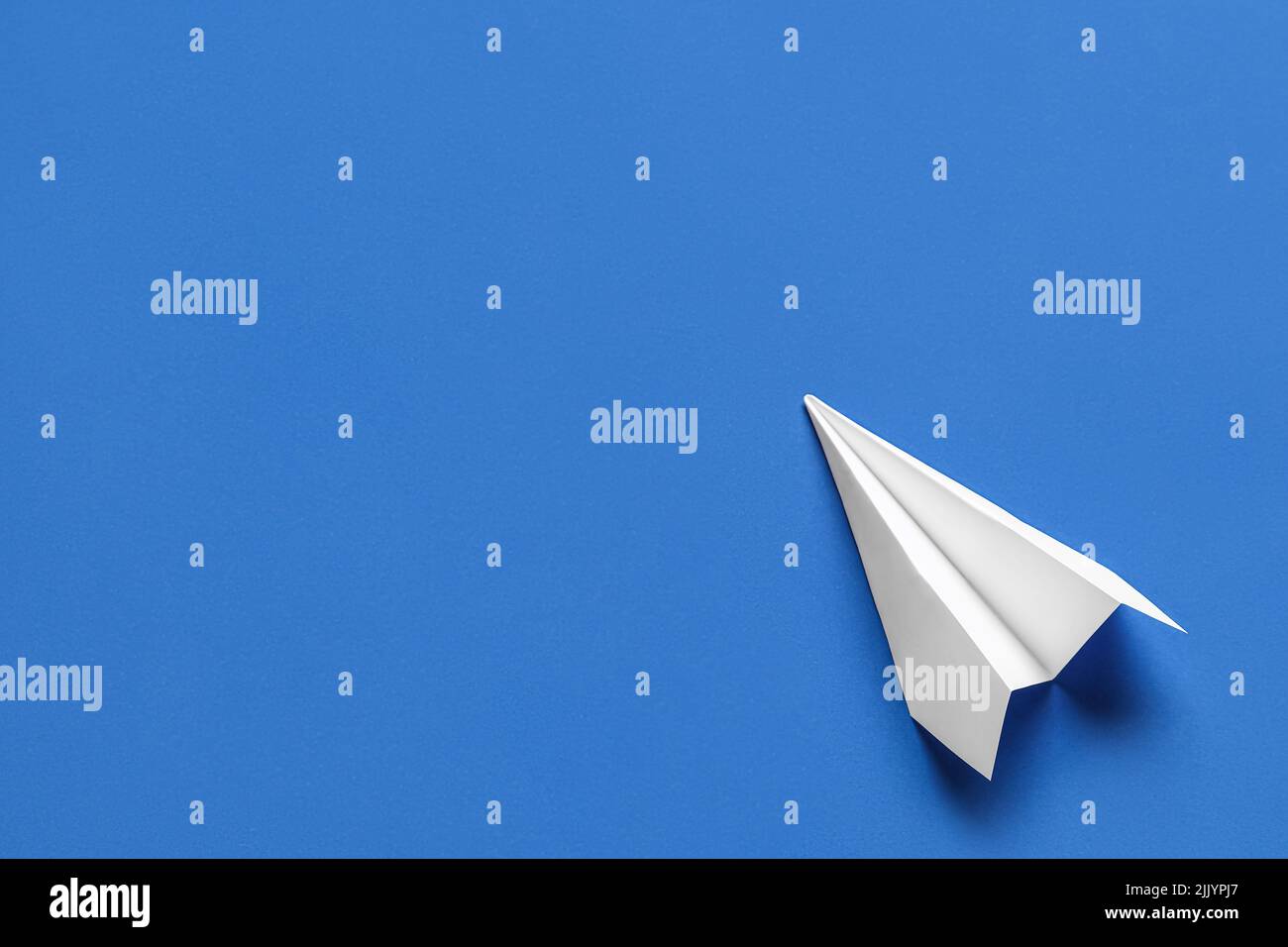 Paper plane on blue background Stock Photo - Alamy