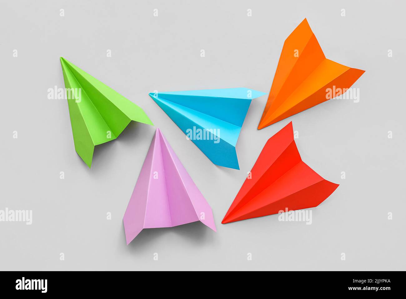 Colorful paper planes on grey background Stock Photo - Alamy