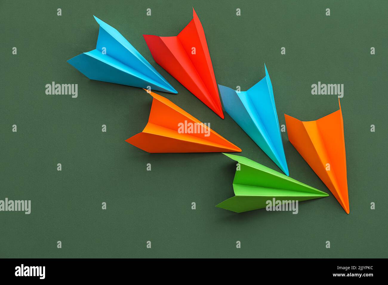 Colorful paper planes on green background Stock Photo - Alamy