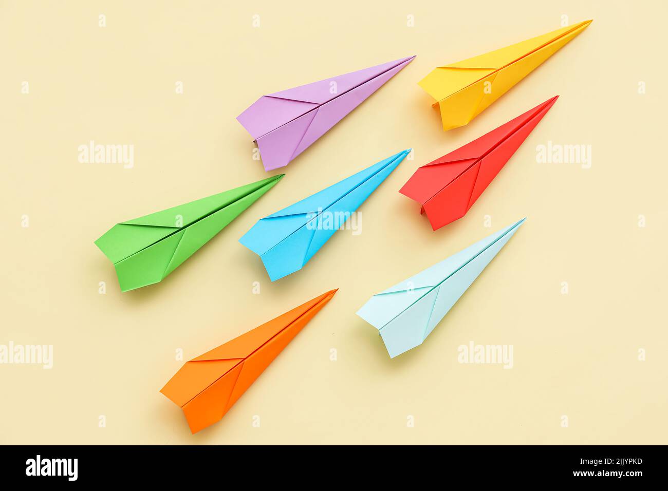 Colorful paper planes on beige background Stock Photo - Alamy