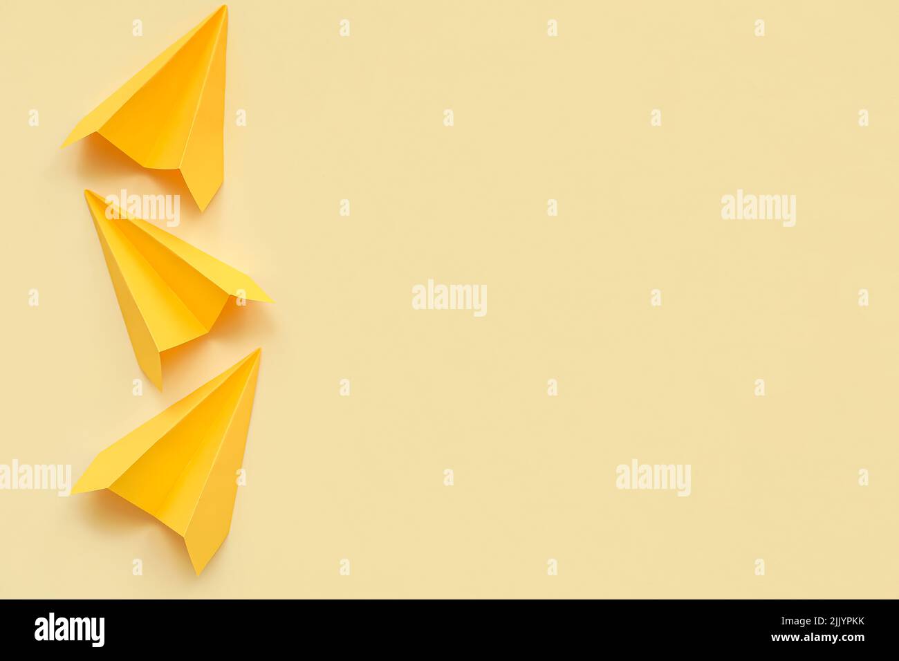 Yellow paper planes on beige background Stock Photo - Alamy