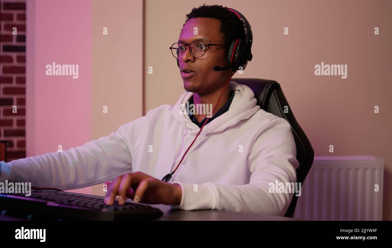 Closeup of african american gamer with gaming headset talking to team ...