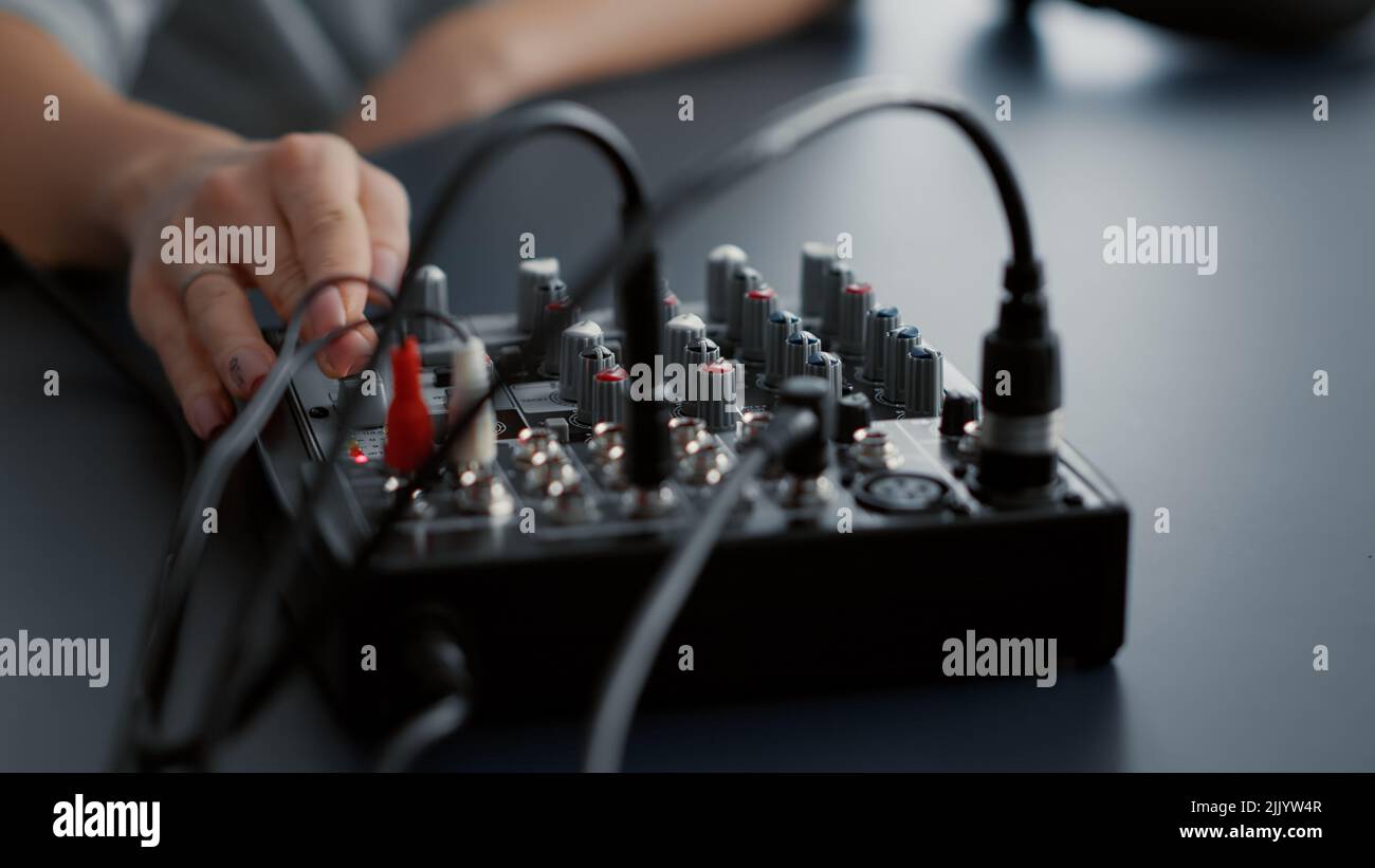 Woman tweaking audio mixer knobs and buttons. Internet radio host ...