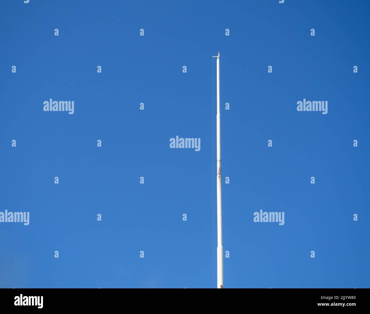 Empty white flagpole against the blue sky. Lowered flag. national Stock ...
