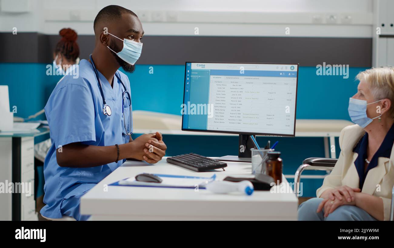 Medical worker talking to woman wheelchair user about disease, dealing ...