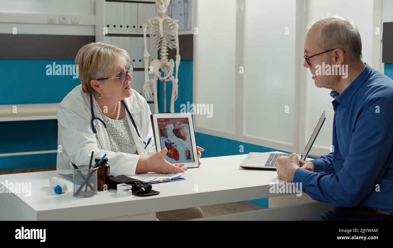 Female physician showing cardiology diagnosis on digital tablet ...