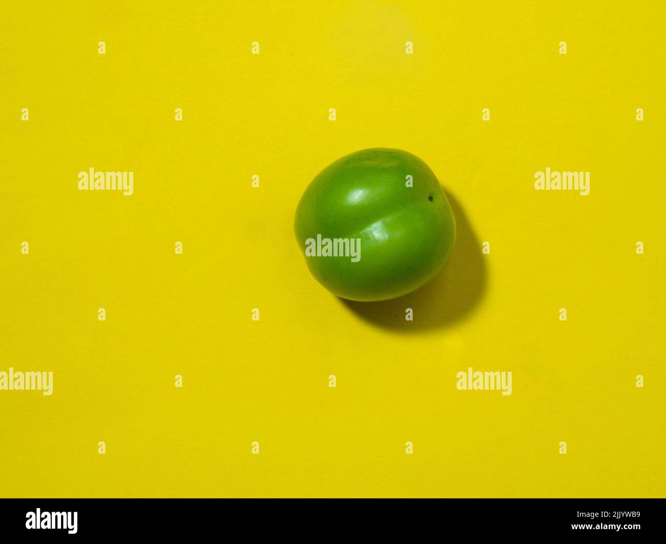 Cherry plum fruits on a yellow background. Healthy green fruit ...