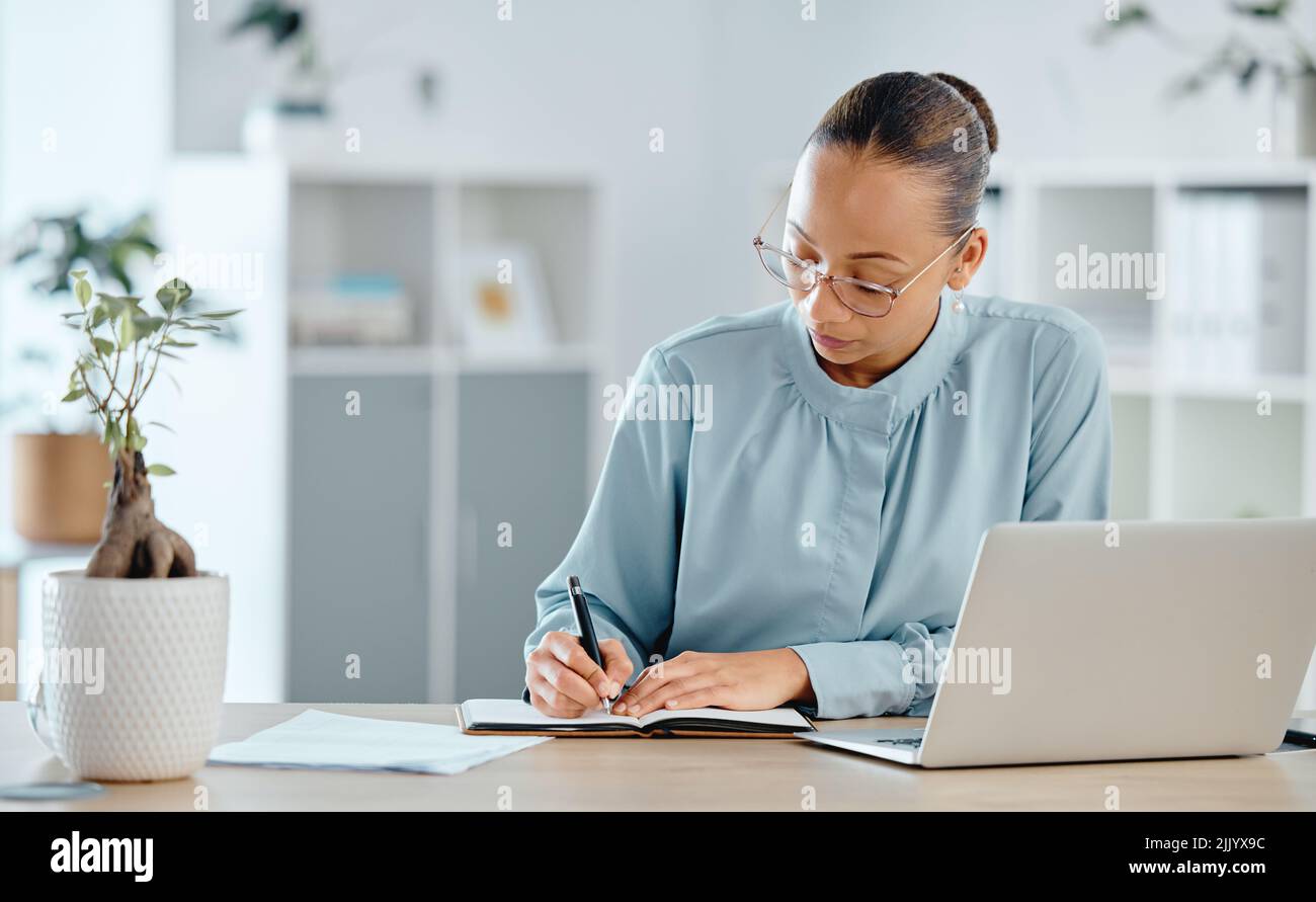 Serious, thinking and confident finance manager writing notes in ...