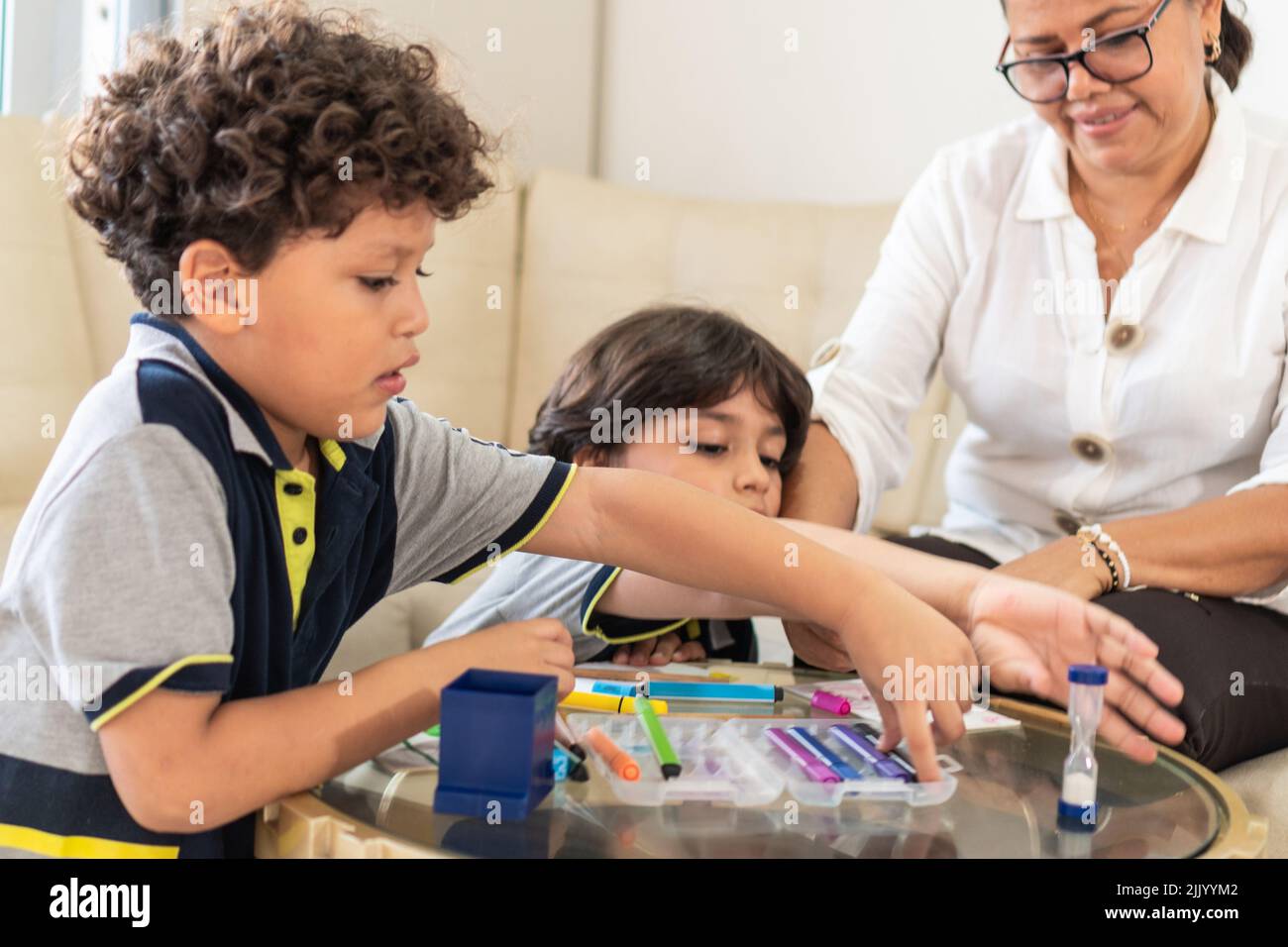 Two children coloring at home with their grandmother Stock Photo - Alamy