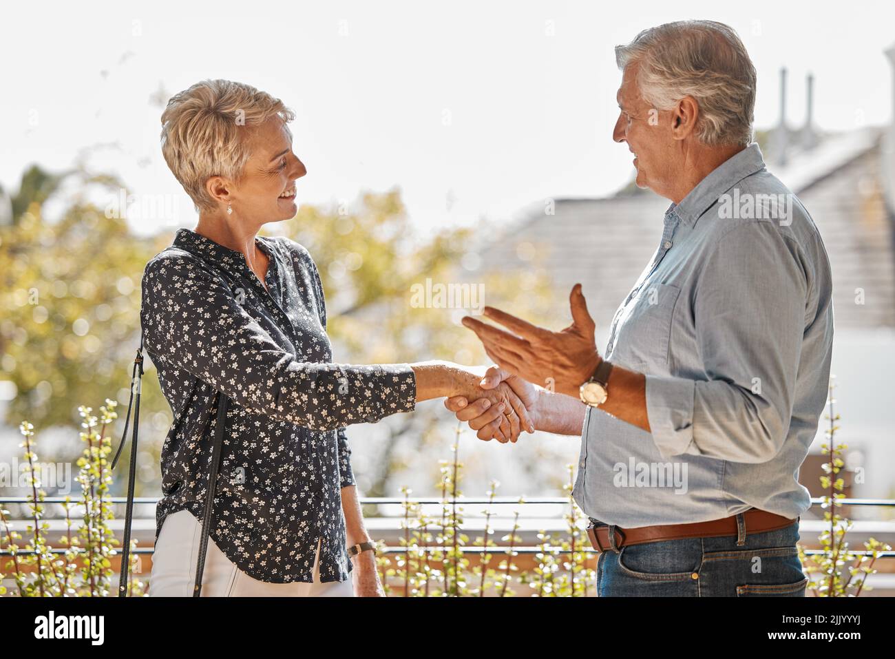 Welcome to your new home. a senior realtor shaking hands with a client ...