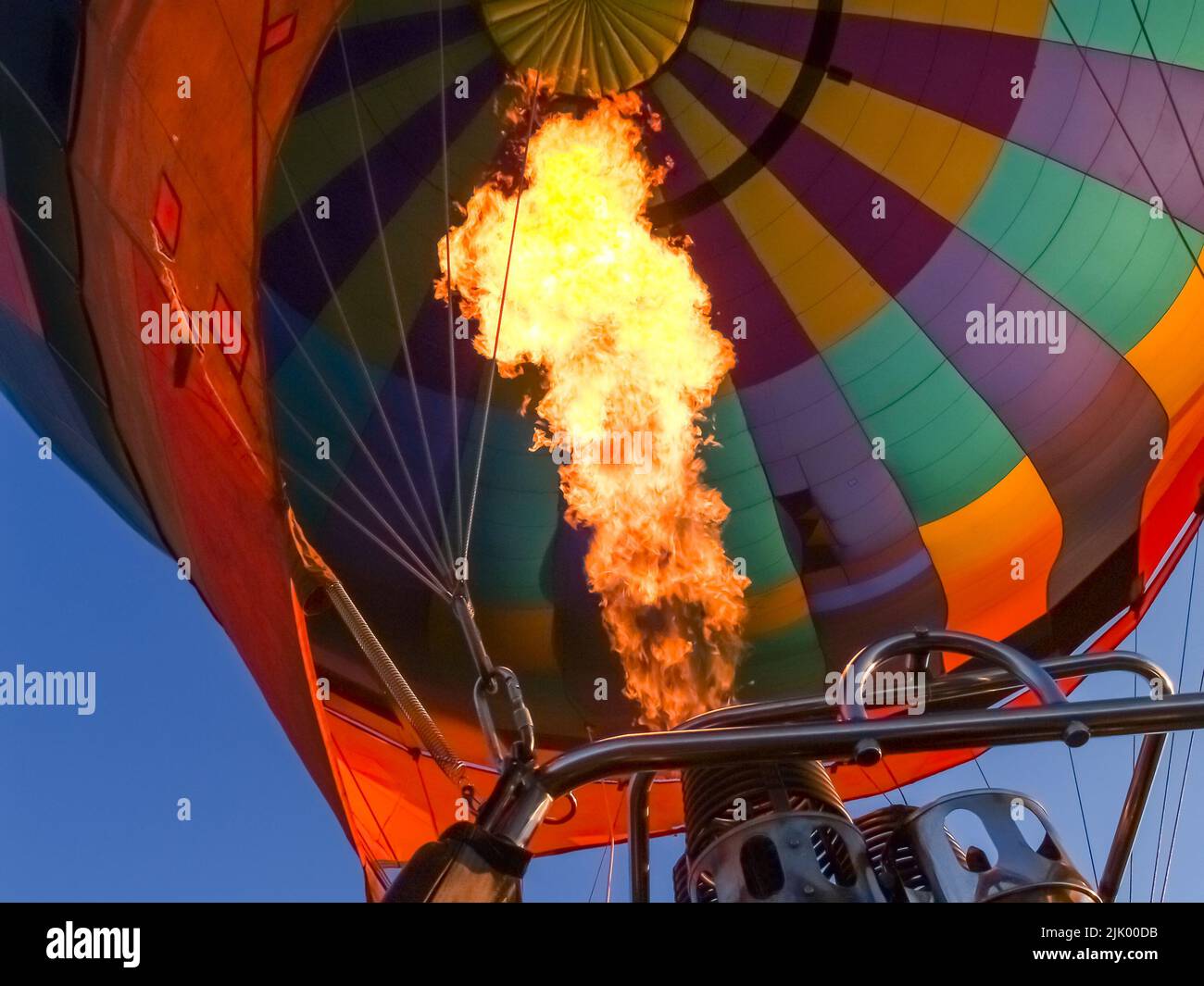 Hot air balloon burner flame fires into canopy as balloon floats ...