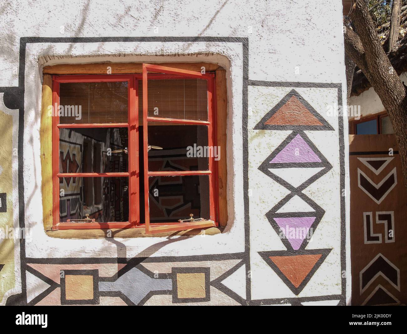 Red steel frame window in building wall with African pattern Stock ...