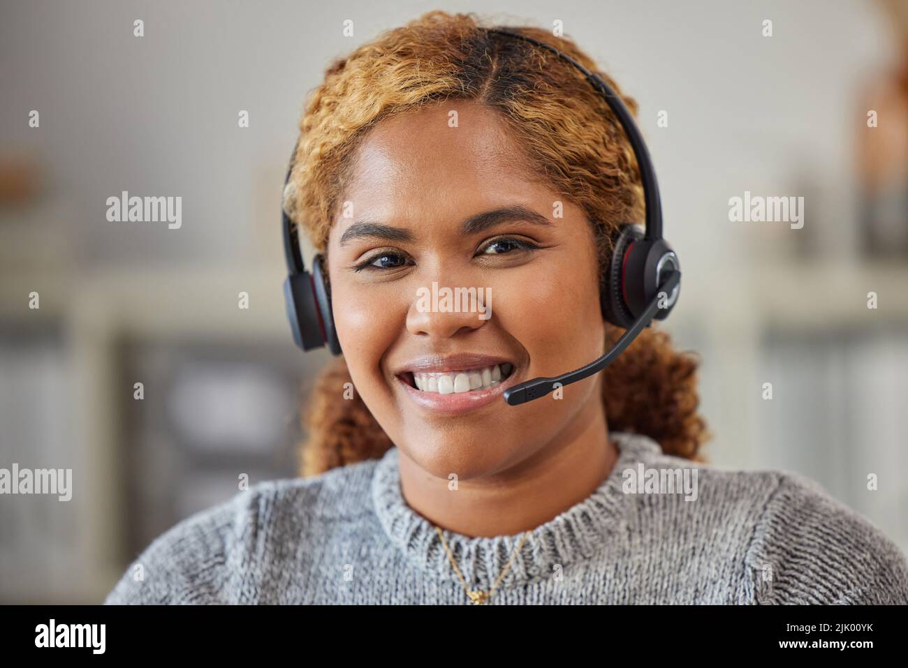African female call center agent smiling and happy to help in her ...
