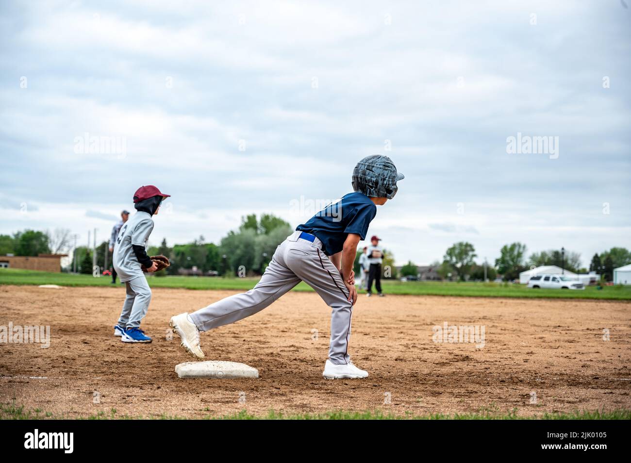 Male youth prepared to run to home base with one foot on and one foot ...