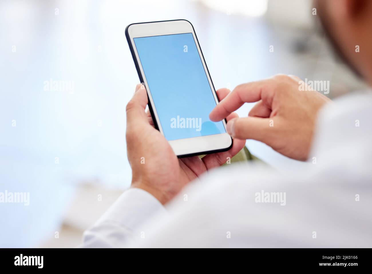 Blank blue screen of a phone with a businessman typing or scrolling the ...