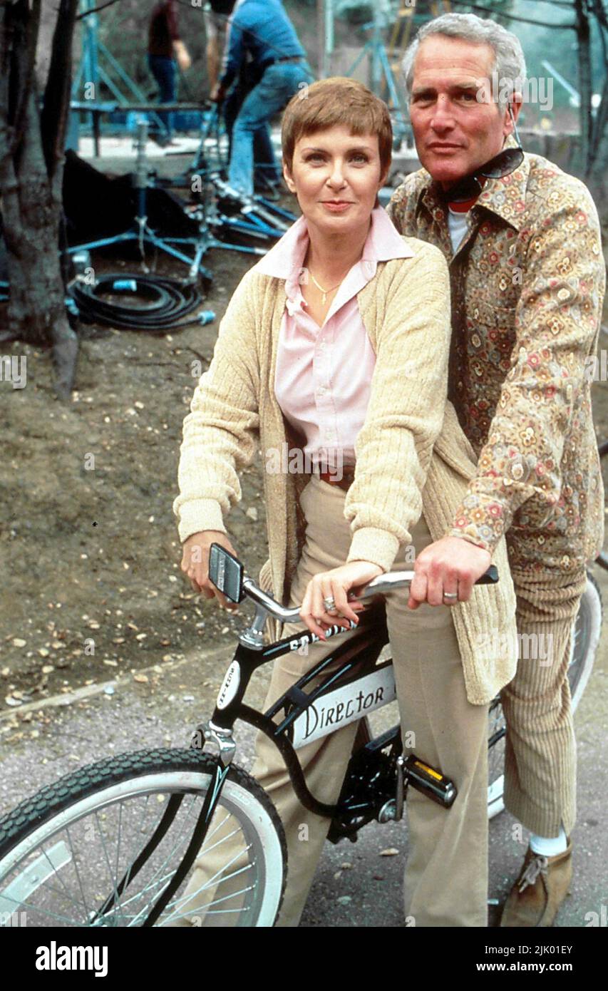 1980 - PAUL NEWMAN and wife JOANNE WOODWARD ride a bike labeled director on a set 1980. Date and ...