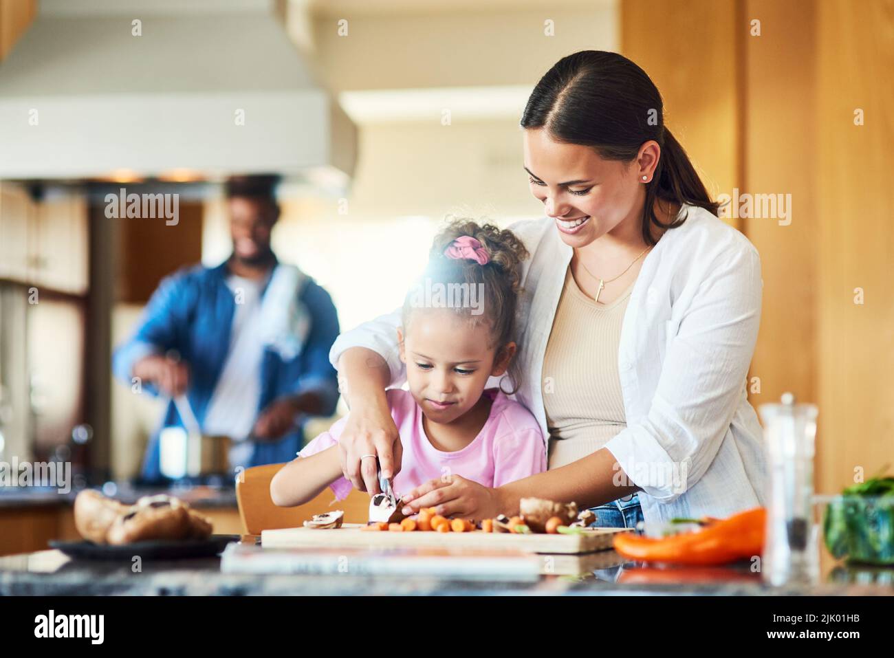 Kids love helping with the cooking. a little girl assisting her mother ...