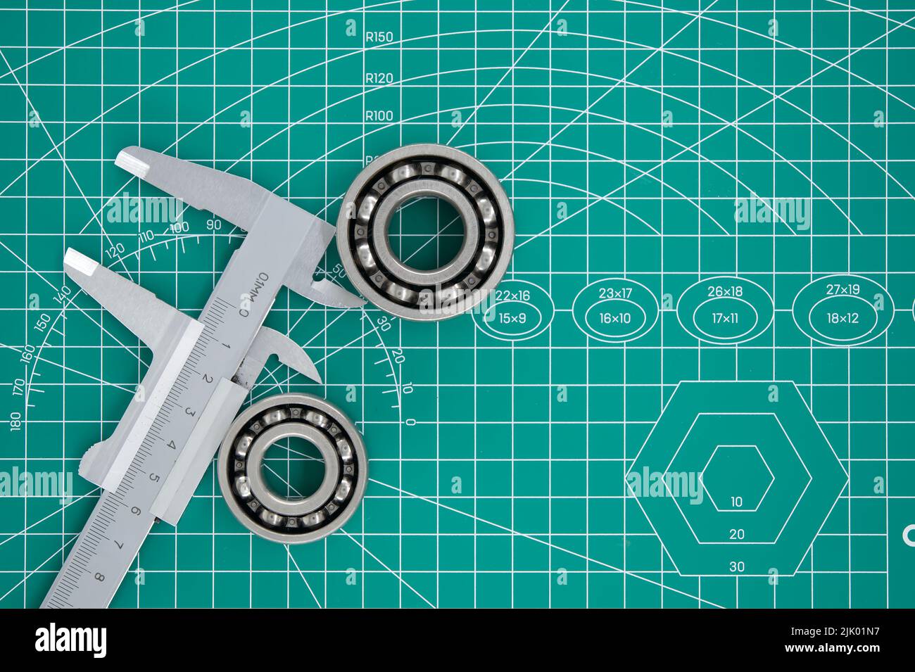 Measure caliper and roller bearings on green cutting mat with free copy ...