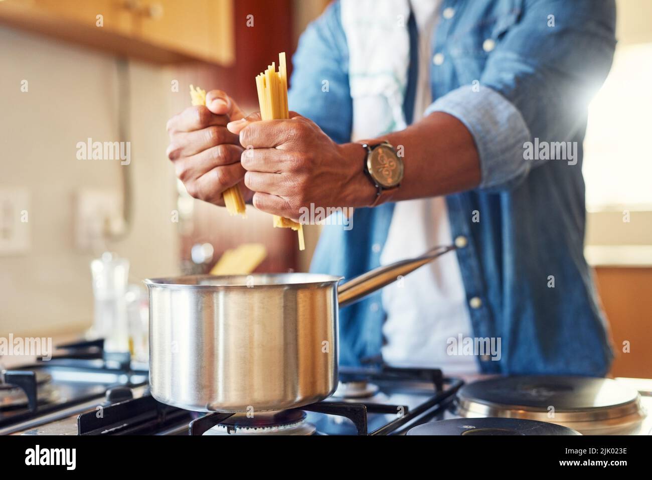 I know how to make a good spaghetti. a man breaking spaghetti before ...