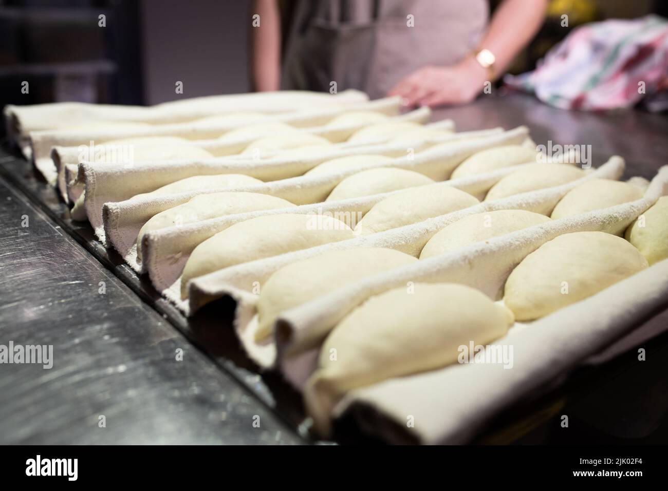 The baker checks the proofing of the molded La Ciriola romana buns ...