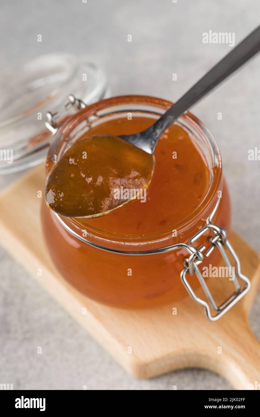Spoon with fruit jam close-up on a jar. Preservation of fruits ...