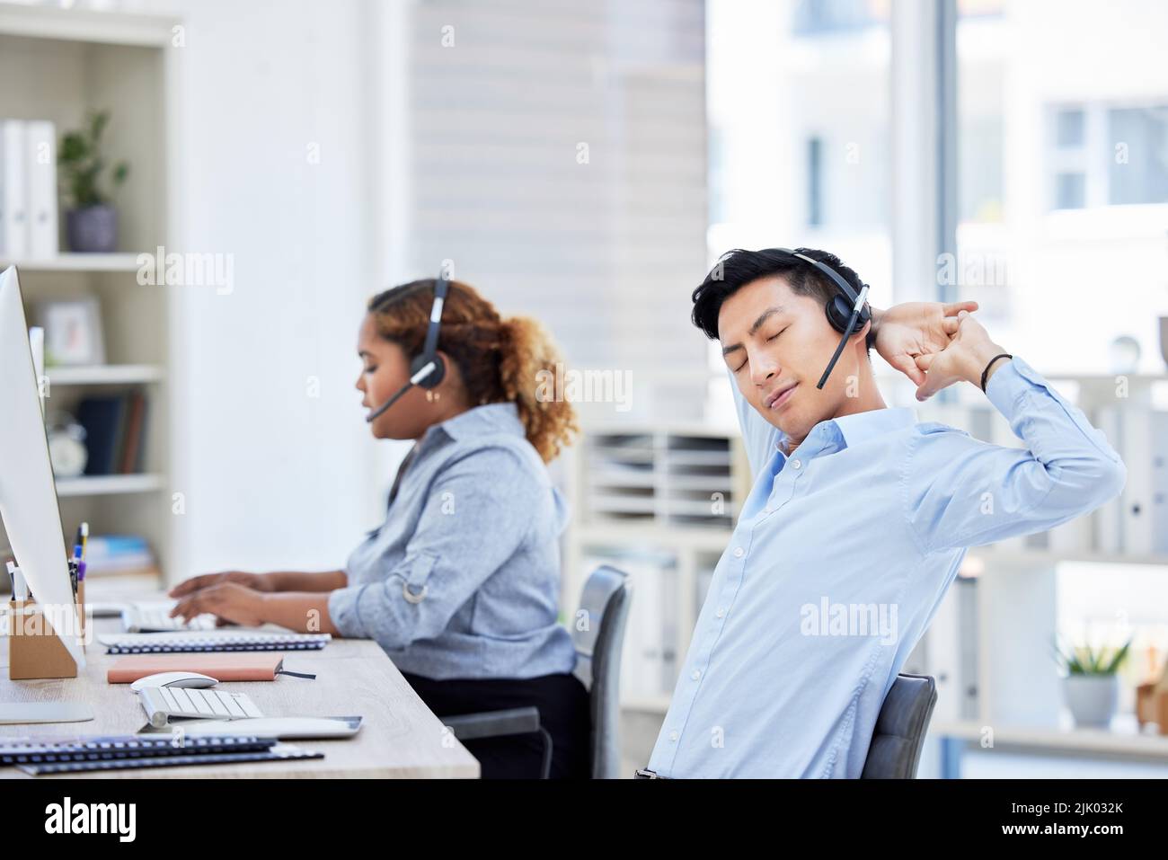 Stretching, stressed and tired call centre agent suffering from burnout ...