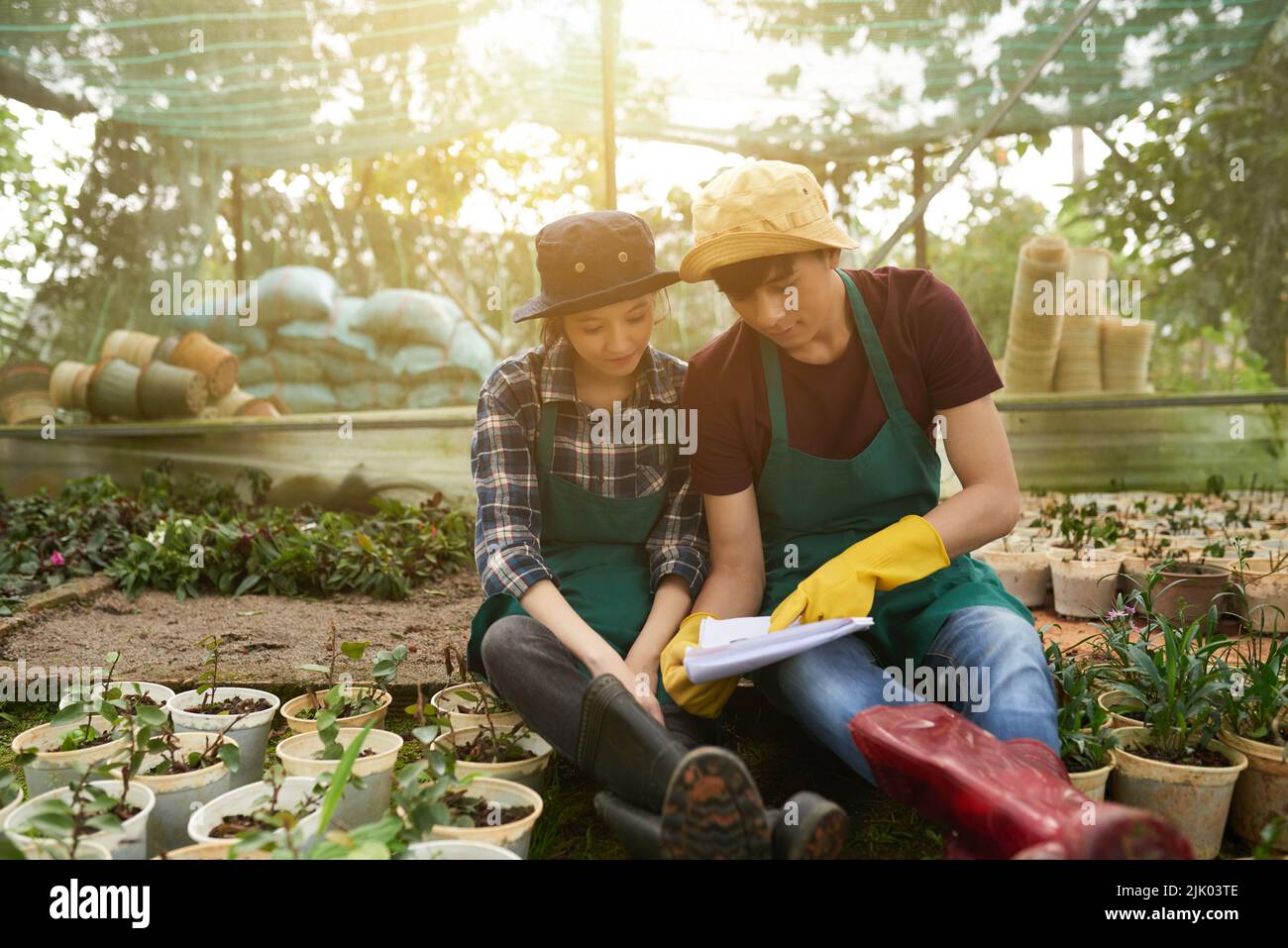 Young gardeners reading information about flowers they are growing Stock Photo - Alamy