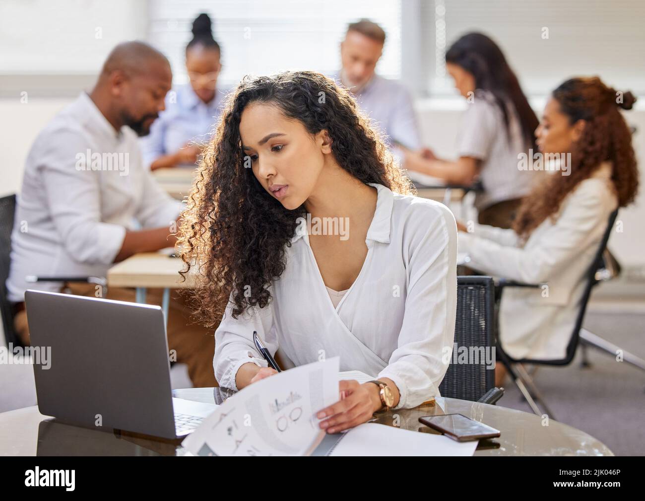 Working on her own to finalise a few figures. a young businesswoman ...