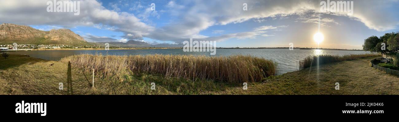 A panoramic view of the sea with grassy coast under the sun in ...