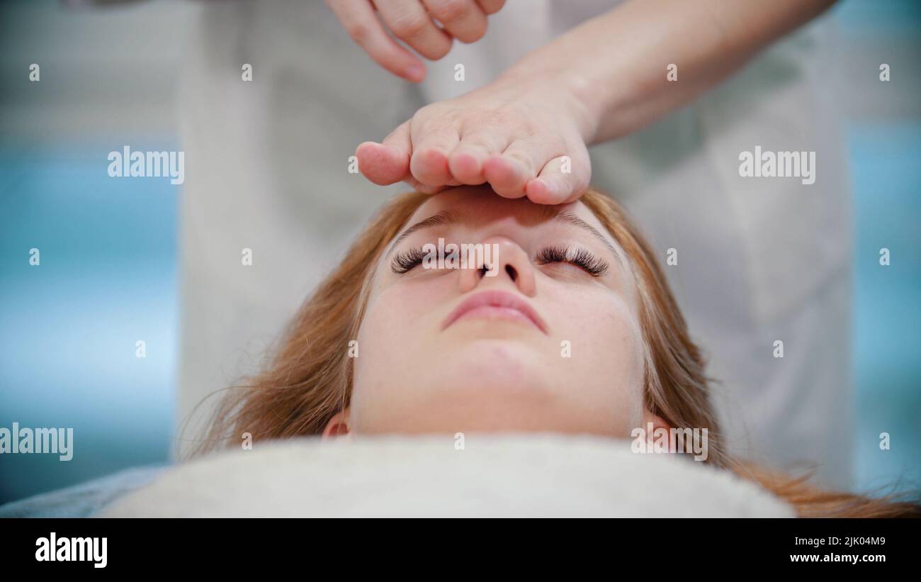 Massage - masseuse is kneading her clients face with palms Stock Photo ...