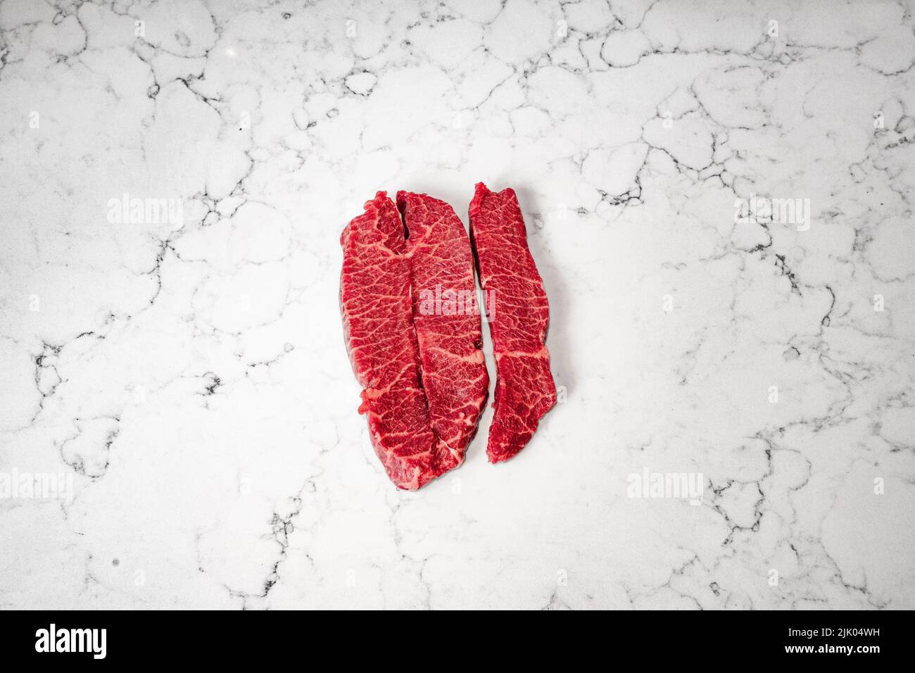 A closeup of flat iron raw steak in white background Stock Photo - Alamy