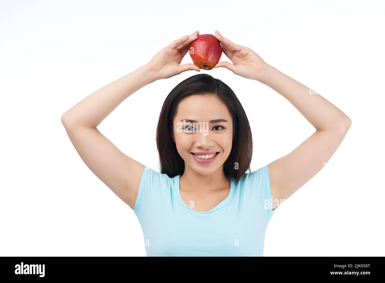 Joyful Asian woman looking at camera with charming smile while holding ...