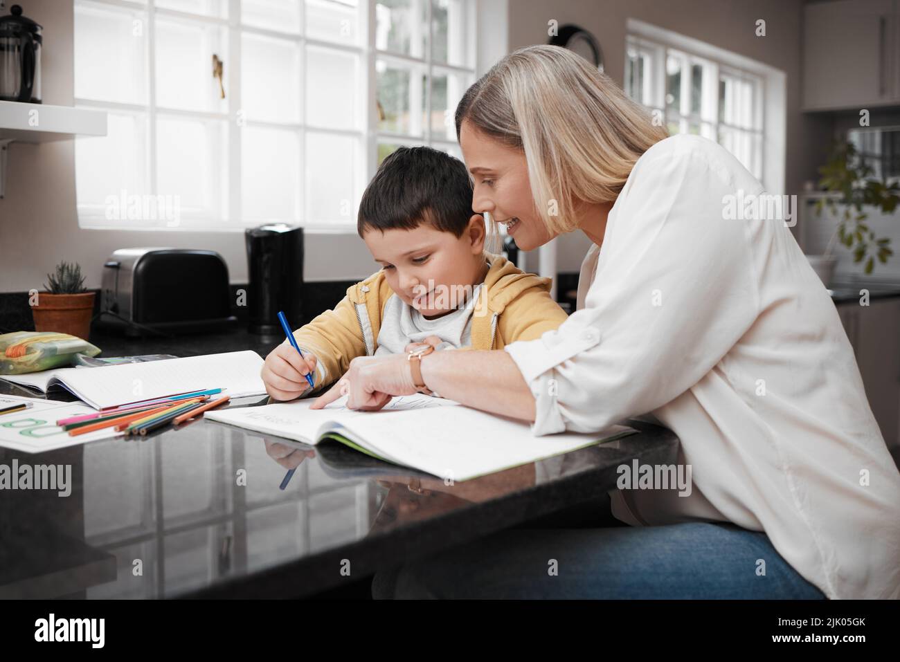 Will you explain it to me. a beautiful mother helping her son with his homework Stock Photo - Alamy