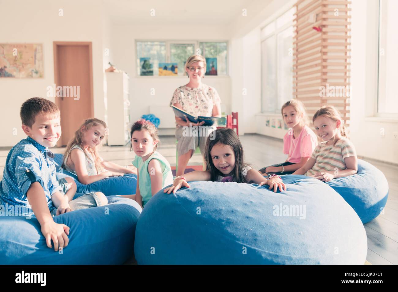 Reading time in elementary school or kindergarten, teacher reading a ...