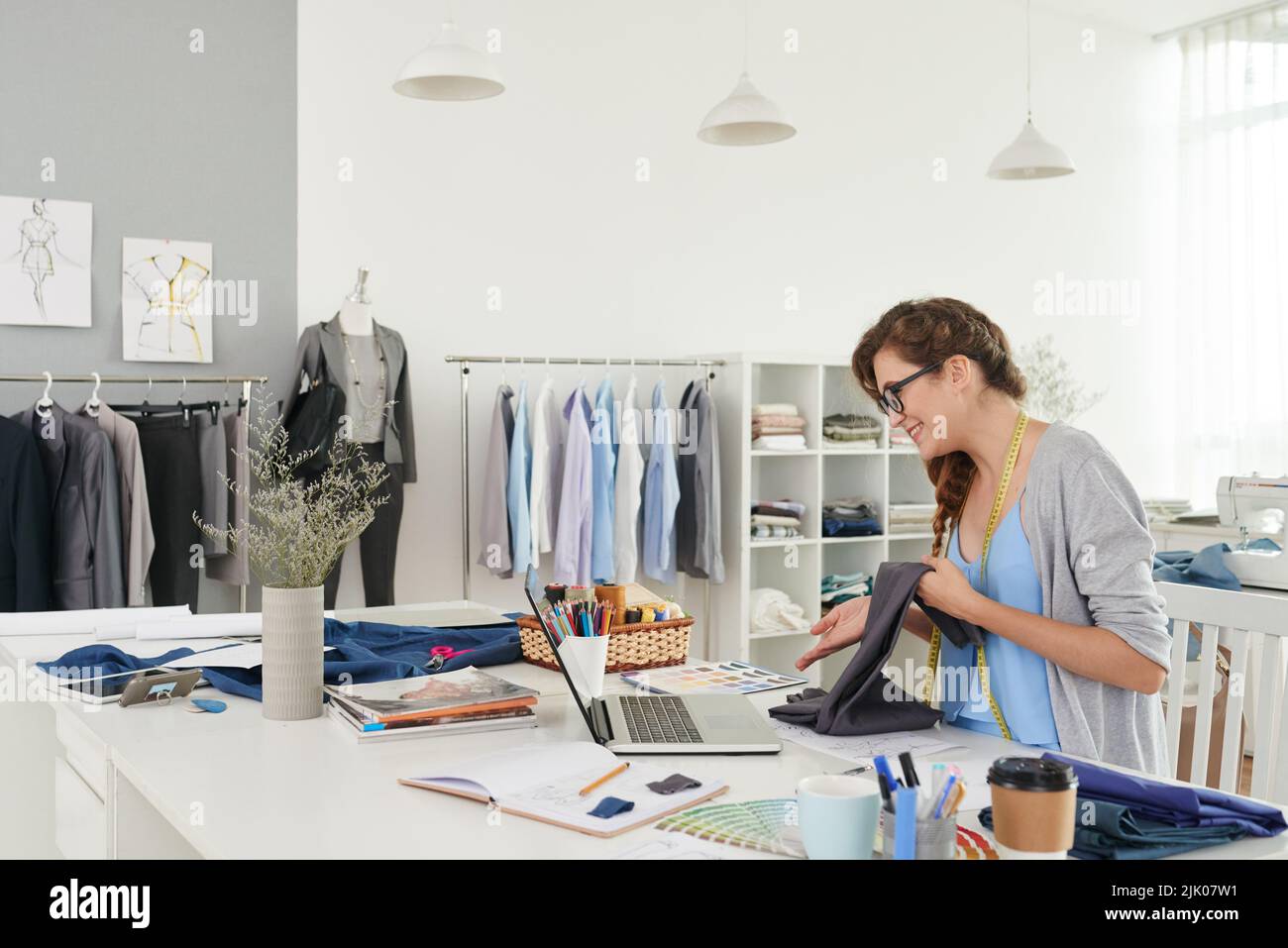 Tailor videocalling to client. She is showing fabric Stock Photo - Alamy