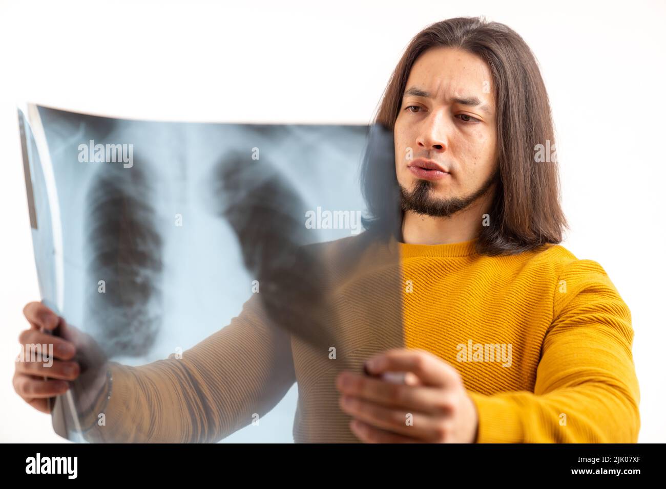 Isolated young long haired bearded hispanic man hanging and analysing ...