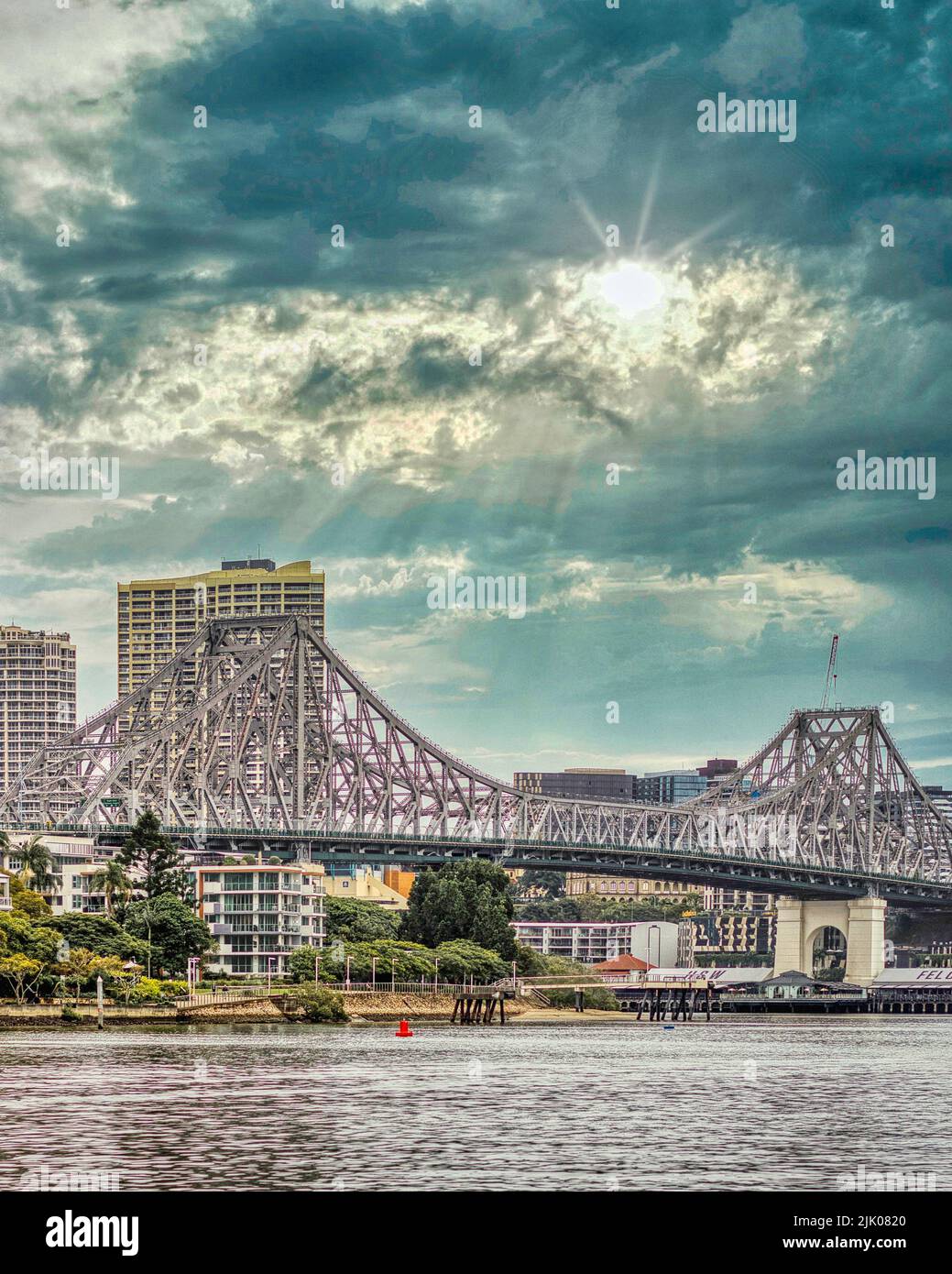An aerial view of railroad bridge over water in background of buildings ...