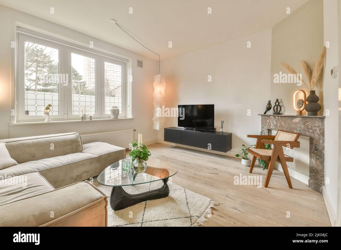 Interior of living room with comfortable sofa and TV against windows in ...