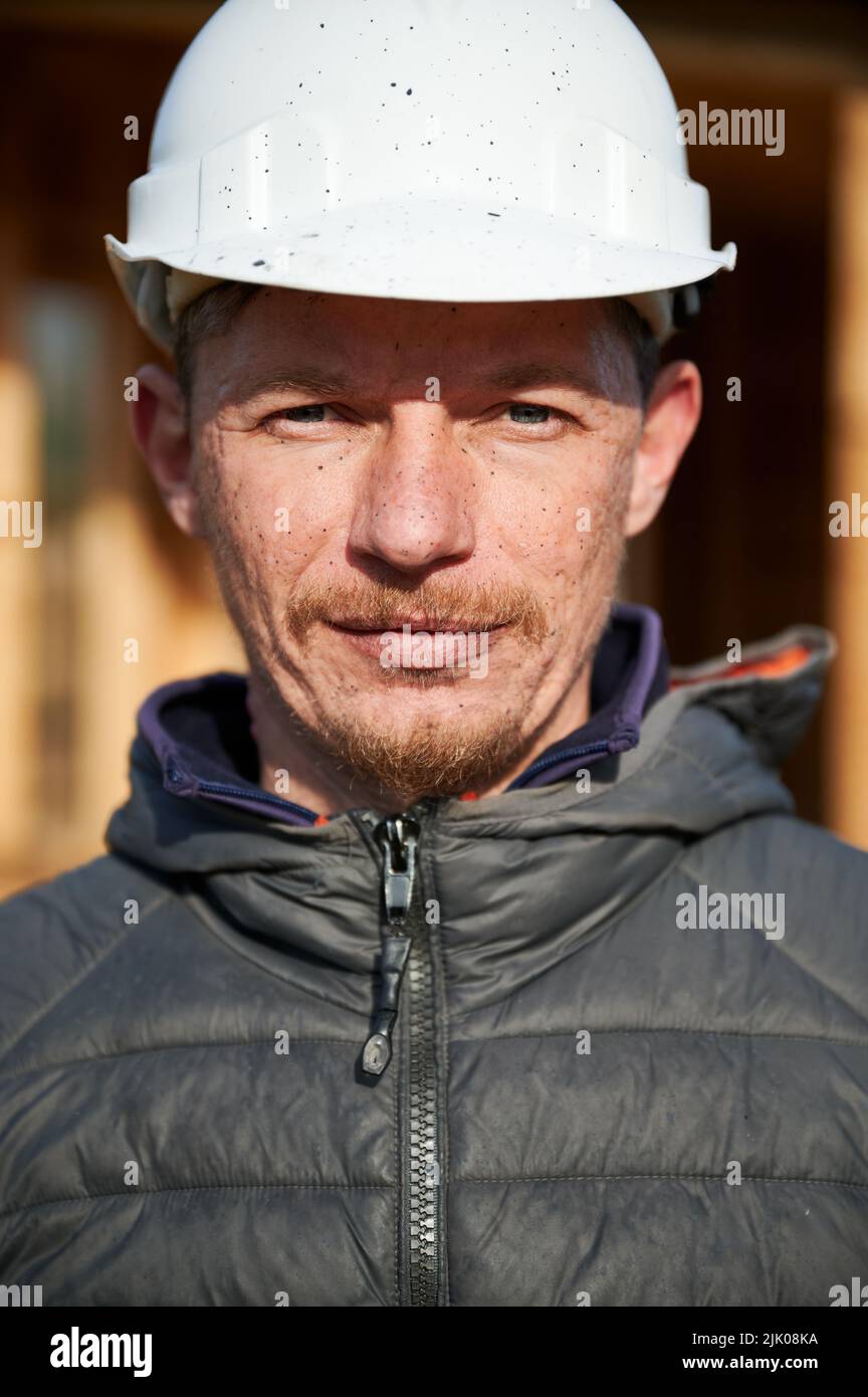 Close up portrait of male builder building wooden frame house. Man ...