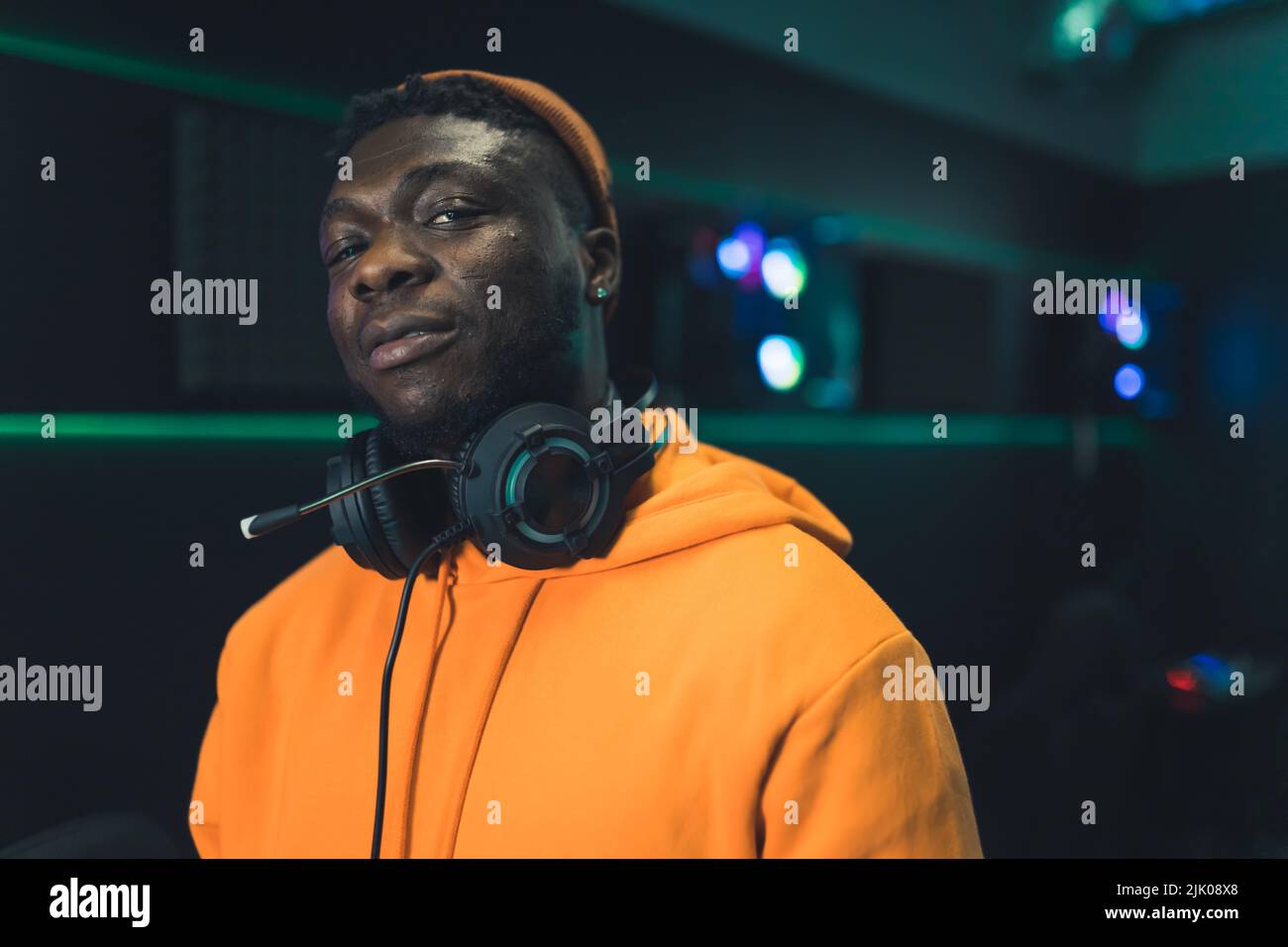 Teenage gamer guy wearing orange hoodie and headset posing for the ...