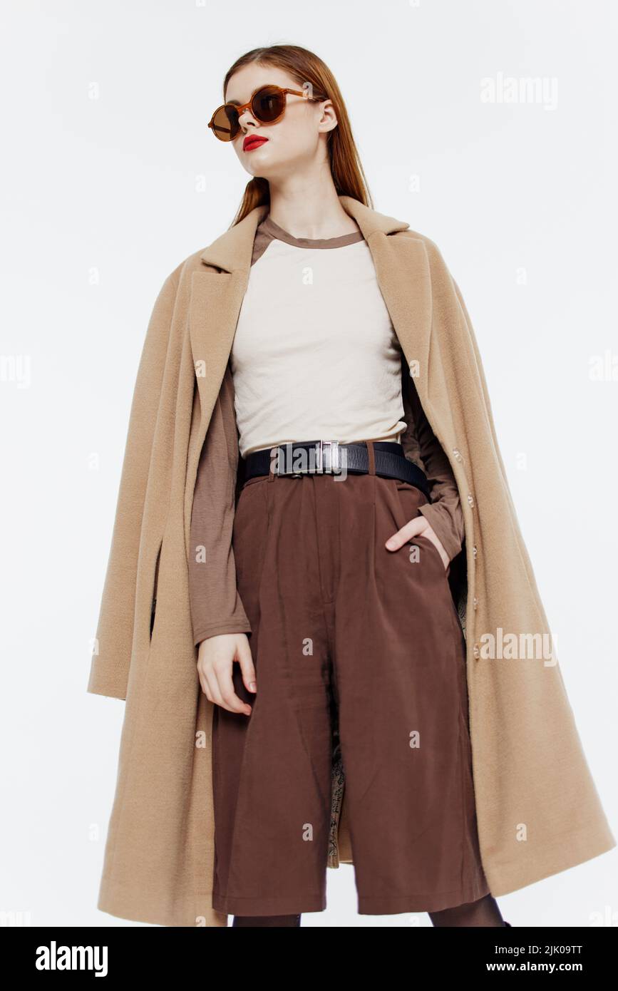 Strict professional model red-haired young woman posing in glasses coat ...