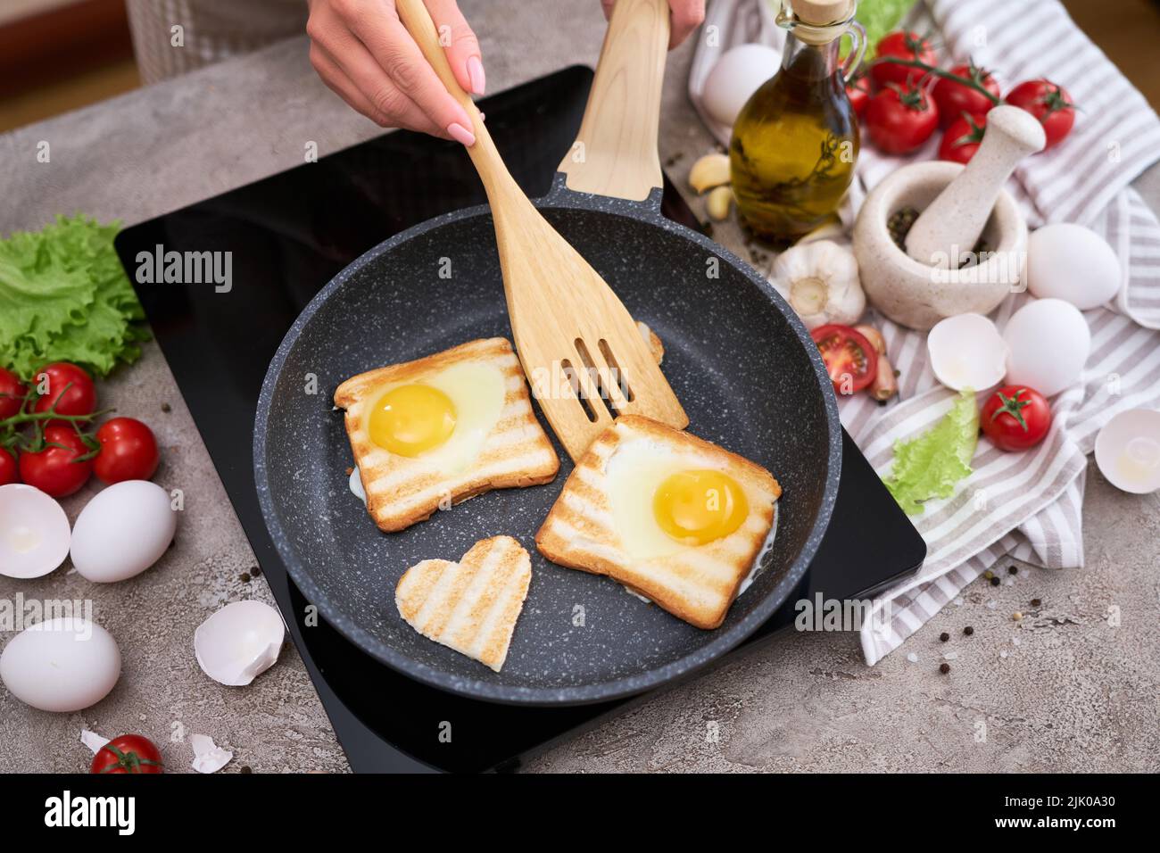 Fried egg Toasts with heart shaped holes on frying pan Stock Photo - Alamy