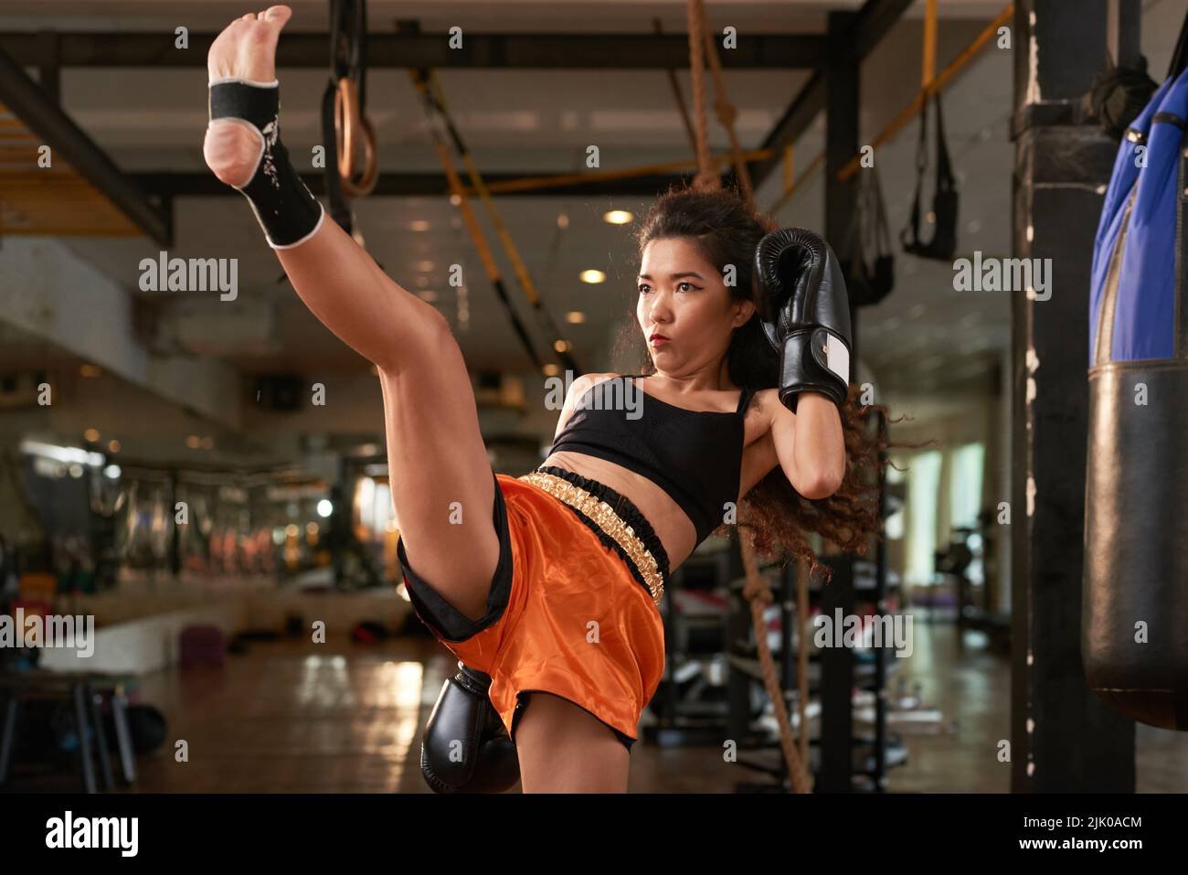 Vietnamese female fighter practicing front kick in gym Stock Photo - Alamy