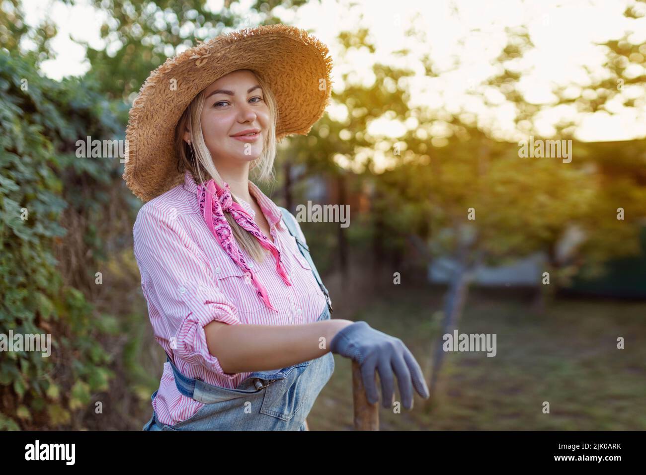 Beautiful young woman gardening outside in summer nature Stock Photo ...